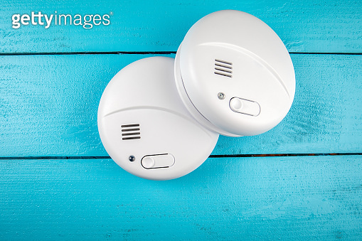 Two smoke detectors on a blue painted wooden surface 이미지 (1334608492 ...