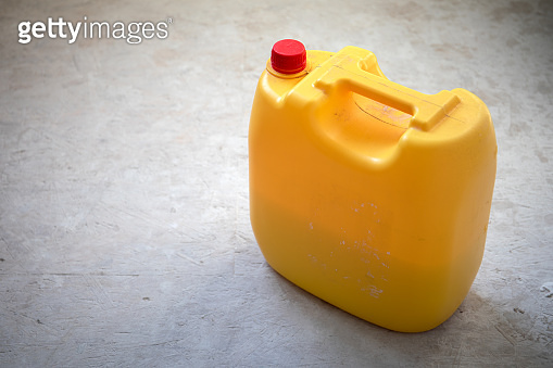Yellow plastic container with a red stopper. Building materials and ...