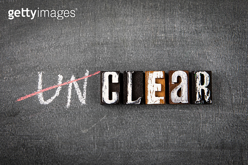 Unclear and Clear concept. Text from wooden letters on a chalk board ...