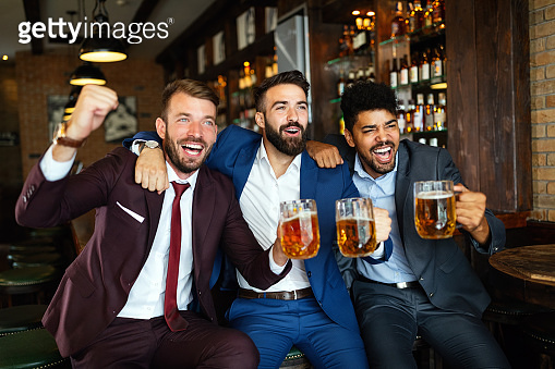 Business men in pub cheering for a sporting event (1348538399) - 게티이미지뱅크