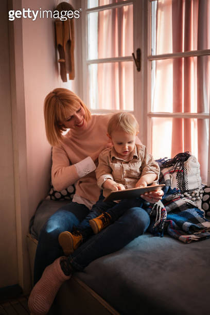 Happy mother with child using digital tablet at home. People technology family happiness concept ...