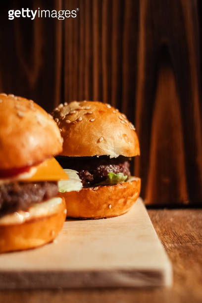 Mini burger on a stand close-up. Children fast food in a restaurant or ...