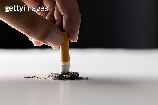 Close up hand putting out a cigarette. man extinguished his cigarette ...