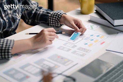 Close up App developer Ux Ui designing with paper model on mobile ...