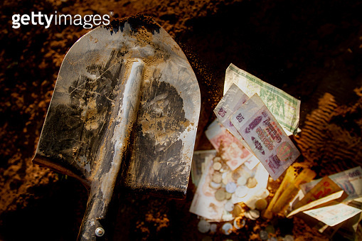 Raking in money with a shovel. Pour the money into the pit (1326893983 ...