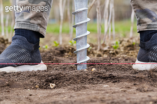 the builder twists the foundation made of screw piles. Lightweight and ...