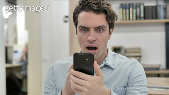 Shocked Man in Awe while Using Smartphone 이미지 (1340713612) - 게티이미지뱅크