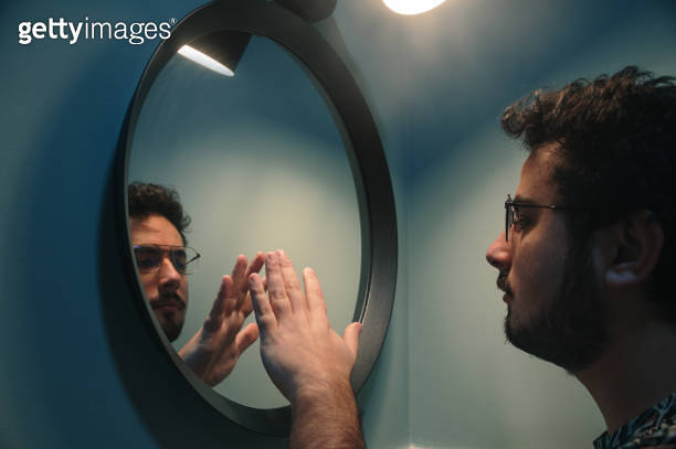 Hand touching its reflection on a mirror (1302427940) - 게티이미지뱅크