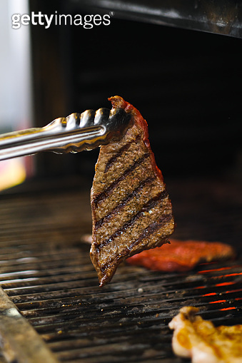 Cooking meat and 2d on fire. Grill and barbecue. Chef cats steak in the ...