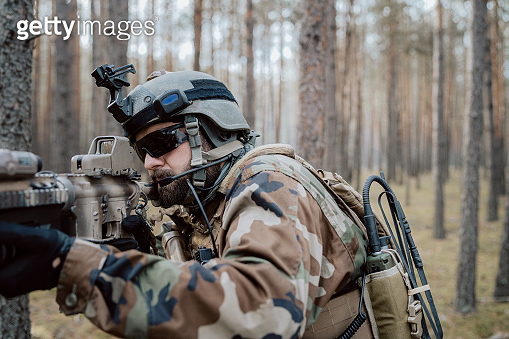 A soldier in a special military uniform, with a helmet on his head and ...