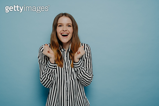 Smiling young woman being excited and celebrating success 이미지 ...
