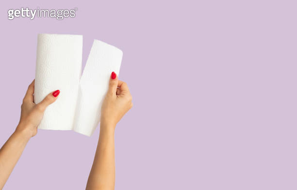 woman hand holds and tears off white paper towel. Tear off napkin ...