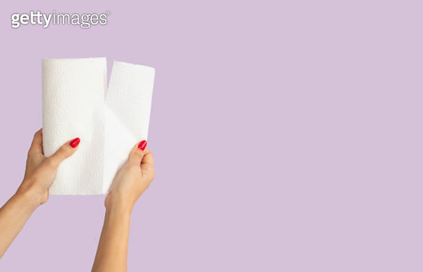 woman hand holds and tears off white paper towel. Tear off napkin ...