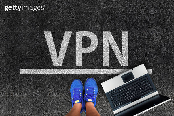 Legs in shoes standing next to laptop and word VPN (1293897962) - 게티이미지뱅크