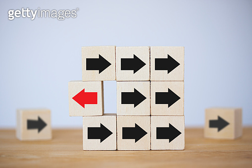 Wooden block with red arrow facing opposite direction black arrows ...
