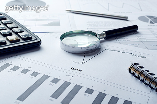 Closeup of magnifier glass, calcilator on the business profit documents ...
