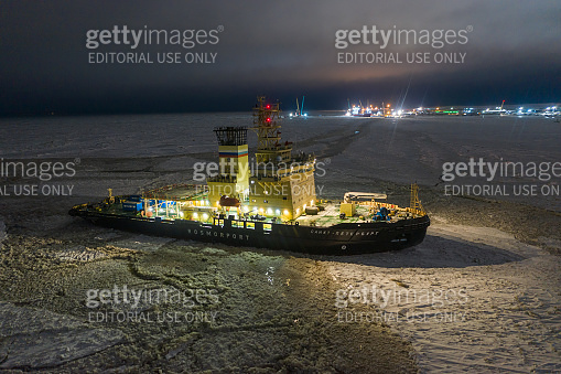 The icebreaker is in the ice at night. The icebreaker shines with all ...