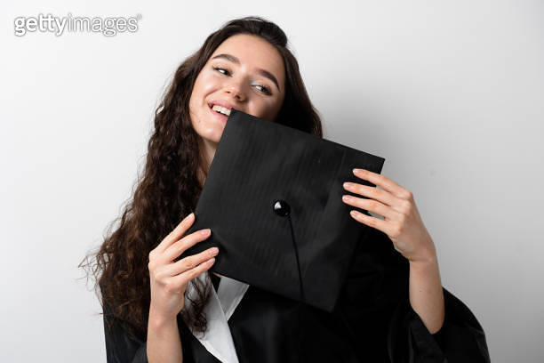 Graduate girl with master degree in black graduation gown and cap on ...
