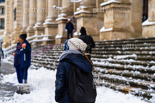 People wearing winter coats on snowy street in Bucharest, Romania, 2021 ...