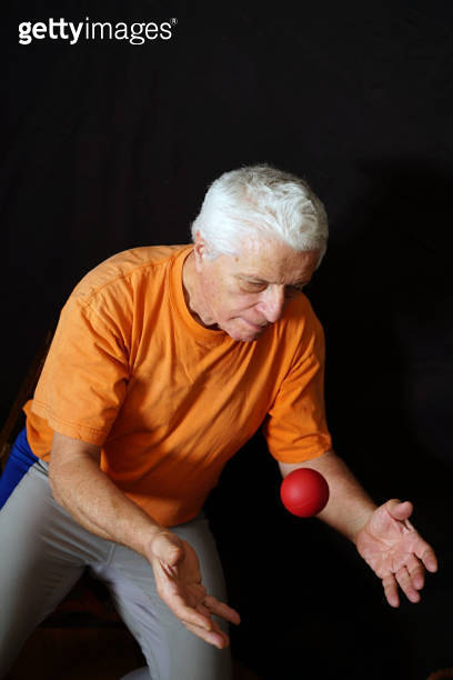 Parkinson Disease patient, standing and juggling with a little ball in ...