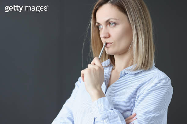 Pensive businesswoman holds pen and looks into distance 이미지 (1298264382 ...