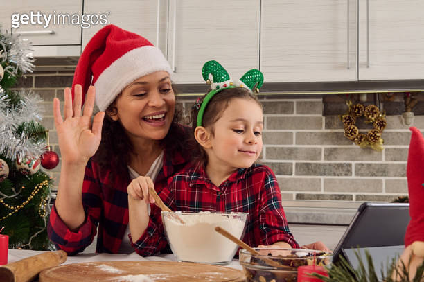 Happy mom in Santa hat and her beautiful little daughter greeting while ...