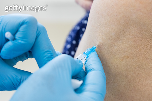 Senior woman receiving vaccine. Medical worker vaccinating an elderly ...