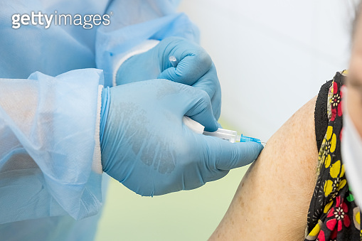 Senior woman receiving vaccine. Medical worker vaccinating an elderly ...