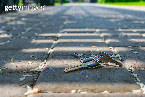 Lost house keys lying on the sidewalk in the shade (1345490035) - 게티이미지뱅크