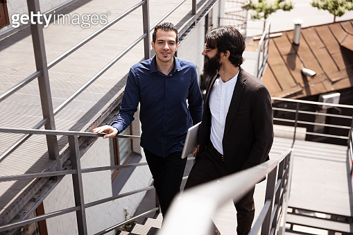 Young men working in modern office using devices and gadgets. Making ...