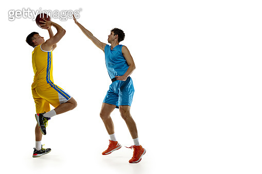 Two male athletes, basketball players in action, motion compete during ...