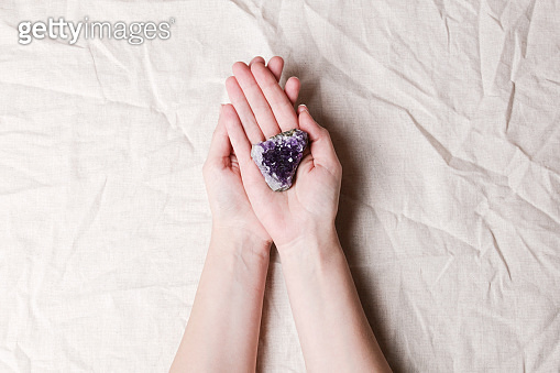 druse raw purple amethyst crystal on piece of stone on woman hand on ...