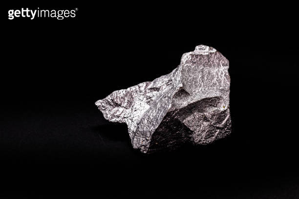 raw zinc nugget on isolated black background, metal used in alloy and ...