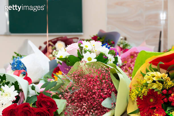A bouquet of beautiful bright flowers on a school desk on September 1 ...