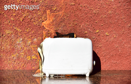 Burning toaster. Toaster with toast caught on fire over table. 이미지 ...
