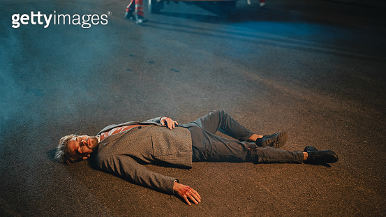 Shot of a Young of a Bloody Man Lying on the Pavement after Traffic ...