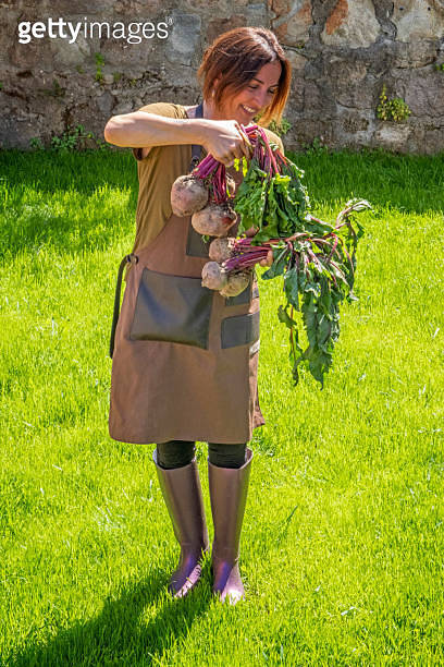 Happy young woman posing and laughing with her freshly harvested red ...