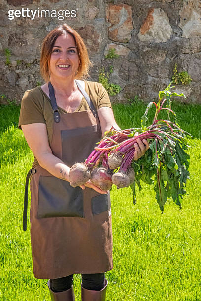 Happy young woman posing and laughing with her freshly harvested red ...