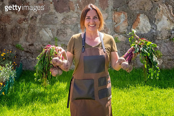 Happy young woman posing and laughing with her freshly harvested red ...