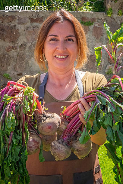 Happy young woman posing and laughing with her freshly harvested red ...