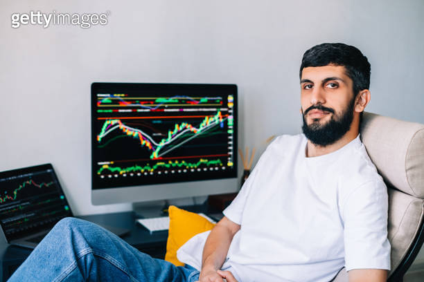 Portrait of caucasian businessman trading online, using computer on ...