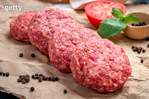 Homemade raw ground beef and Burger Patty with Basil, tomatoes and ...