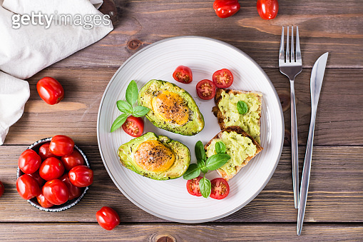 Ready-to-eat appetizer baked avocado with egg, toast and cherry ...