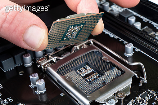 Electronic engineer installing microprocessor. Maintenance computer cpu hardware. Hand holding a ...