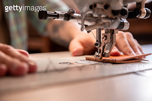 Close up craftsman hands sew stuff blank for wallet use sewing machine ...