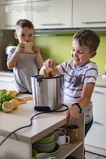 Two funny little brothers cooking and eating together fresh frying ...