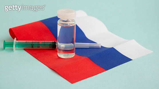 The vaccine and the injection syringe are on the small flag of Russia ...