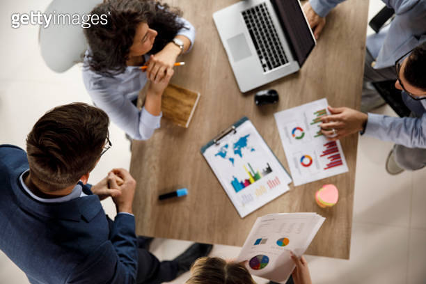 Business people reviewing charts and data on their meeting at the ...