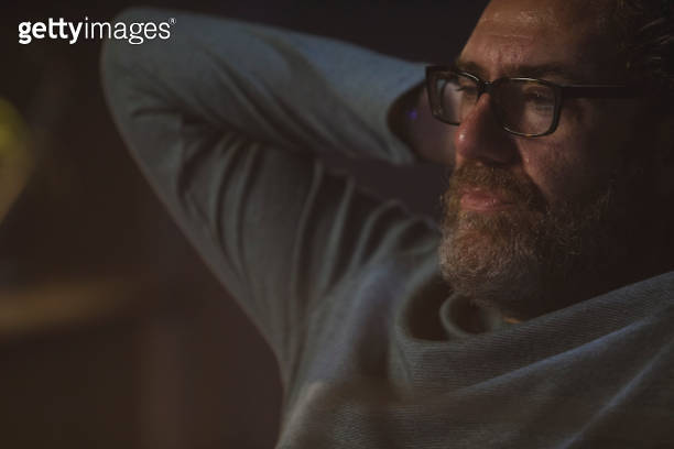 Man leaned back in chair, with hands behind head, contemplating ...