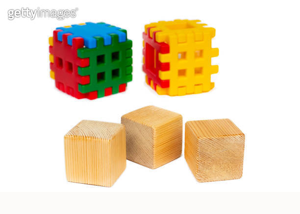 three natural wooden toy blocks and plastic puzzle pieces isolated on ...